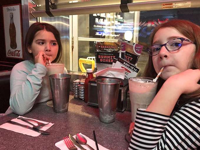 Where milkshakes create memories—these young diners are experiencing the timeless joy of cold, creamy treats in a place their grandparents probably visited too.