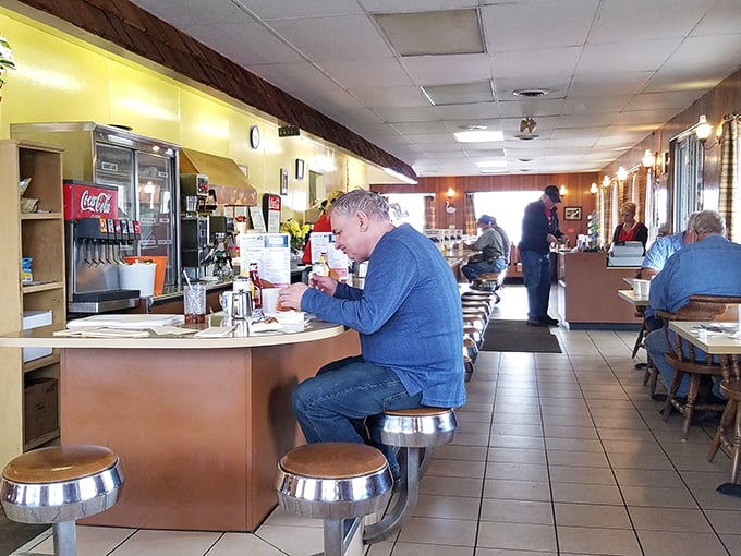 The counter seating – where strangers become neighbors and the coffee refills come with a side of local wisdom.