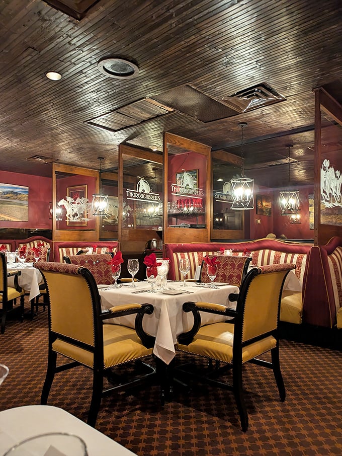 Red walls, white tablecloths, and equestrian art create a dining room that feels both festive and refined. Like Christmas dinner at your sophisticated aunt's house.