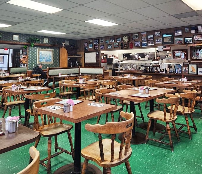 Green carpeting and wooden chairs create a time capsule of comfort. The walls adorned with framed memories tell you this place values history over trends.