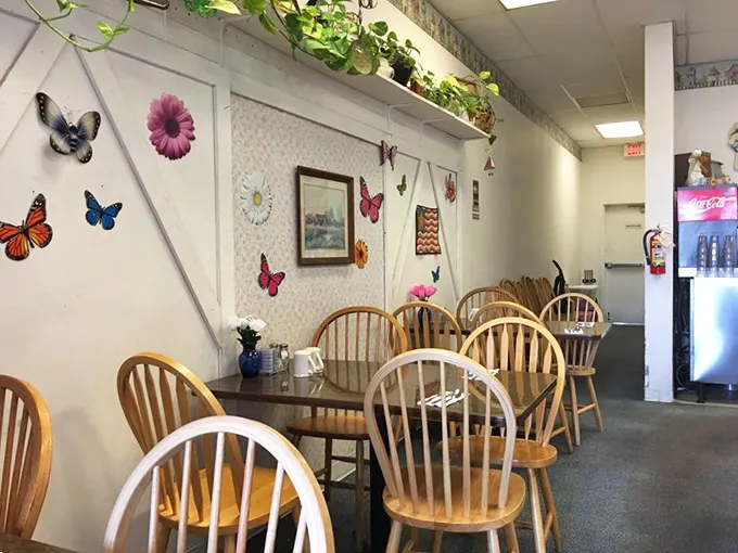 Butterfly decorations and hanging plants create that "your favorite aunt's kitchen" atmosphere where gossip flows as freely as the coffee.