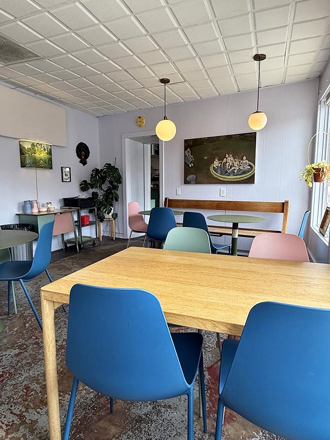 Modern meets cozy with blue chairs, warm wood tables, and globe lights creating the perfect backdrop for both serious conversations and spontaneous laughter.