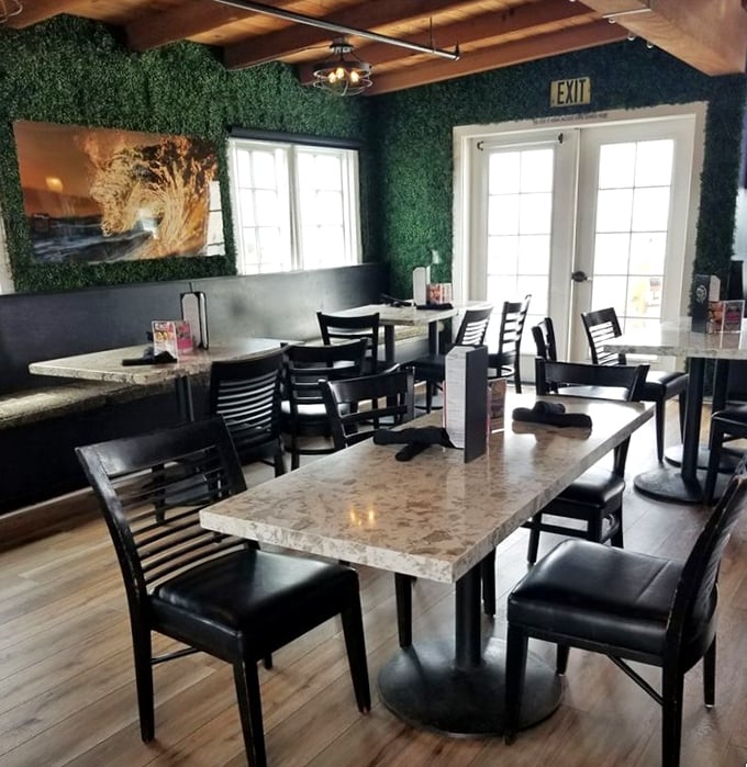 The dining area's artificial greenery wall and ocean artwork create an Instagram-worthy backdrop for your seafood feast—#NoFilterNeeded.