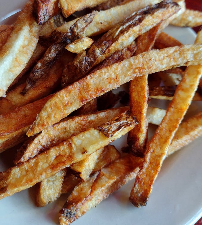 These aren't just french fries—they're golden potato wands of happiness with perfectly crisp exteriors and fluffy insides. The kind worth fighting over until the last one disappears.