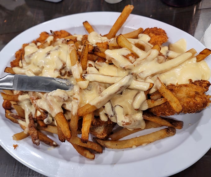 Loaded fries that blur the line between side dish and main event—a cheese-covered masterpiece that requires both a fork and dedication.