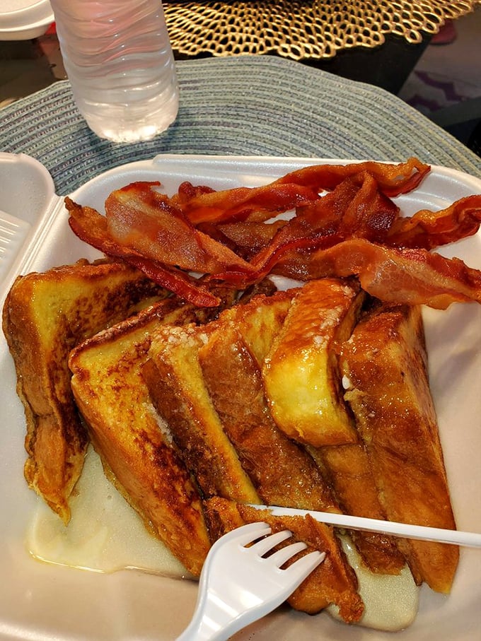 French toast that's achieved custardy perfection inside while maintaining that caramelized exterior—topped with bacon that's clearly been on speaking terms with the griddle.
