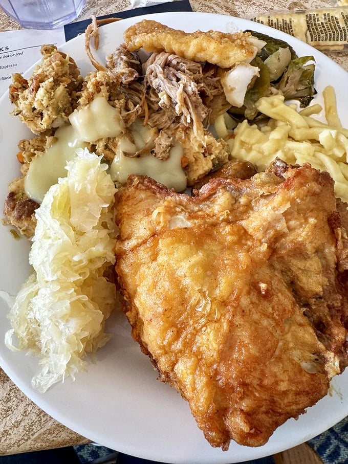 Fried chicken perfection alongside stuffing, sauerkraut, and mac and cheese. This plate is the United Nations of comfort foods, bringing harmony to your taste buds.