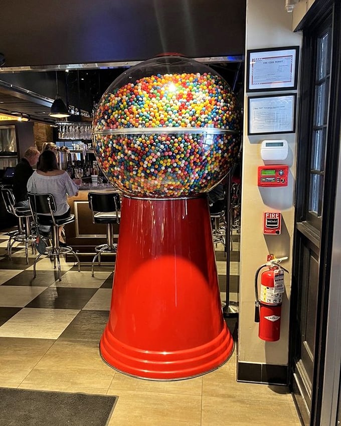 That giant gumball machine isn't just decoration—it's childhood nostalgia supersized, standing guard between cocktail hour and your inner child.