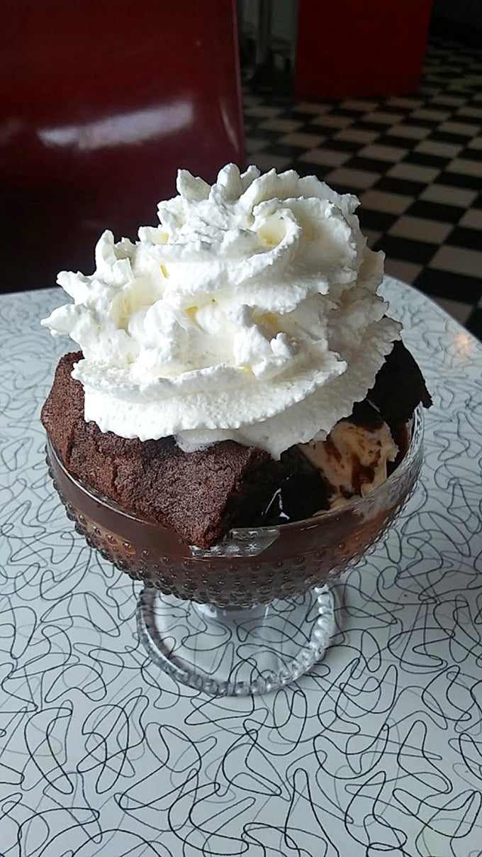 Hot fudge cake with a cloud of whipped cream—proof that sometimes the simplest desserts deliver the most profound happiness.