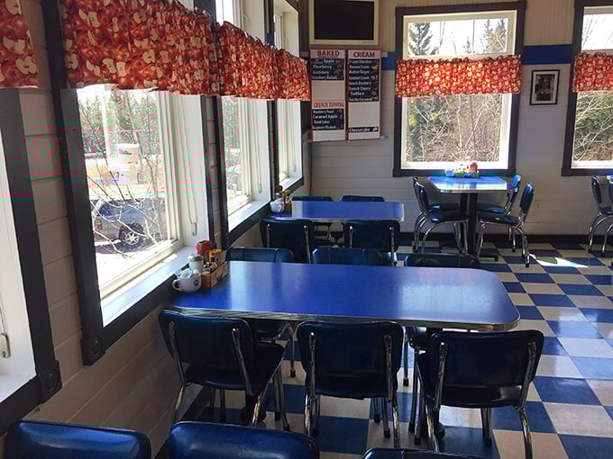 Cherry-red curtains frame windows overlooking northern wilderness, while blue tables invite you to sit and stay awhile. Diner design perfection.