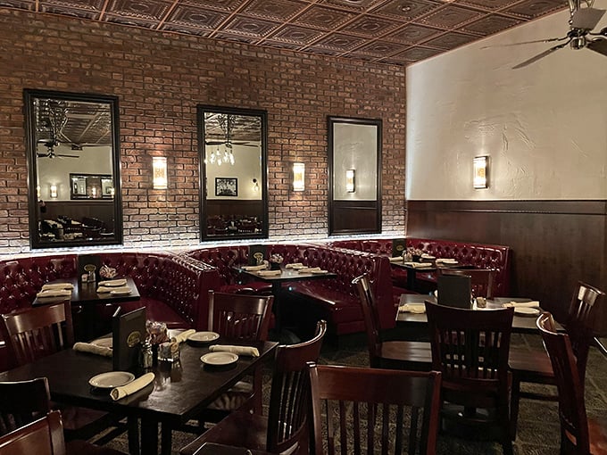 Red leather booths against exposed brick walls—where date nights become anniversaries and business dinners become partnerships.