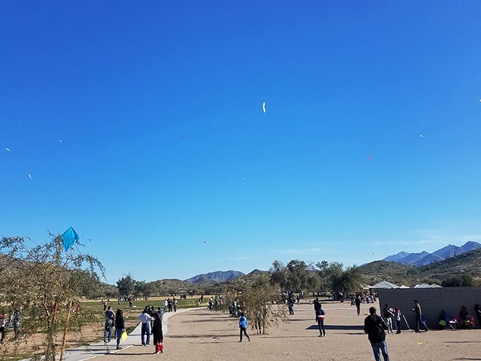 The sky becomes a canvas for colorful kites dancing on desert breezes – proof that sometimes the best entertainment requires looking up, not down at phones.