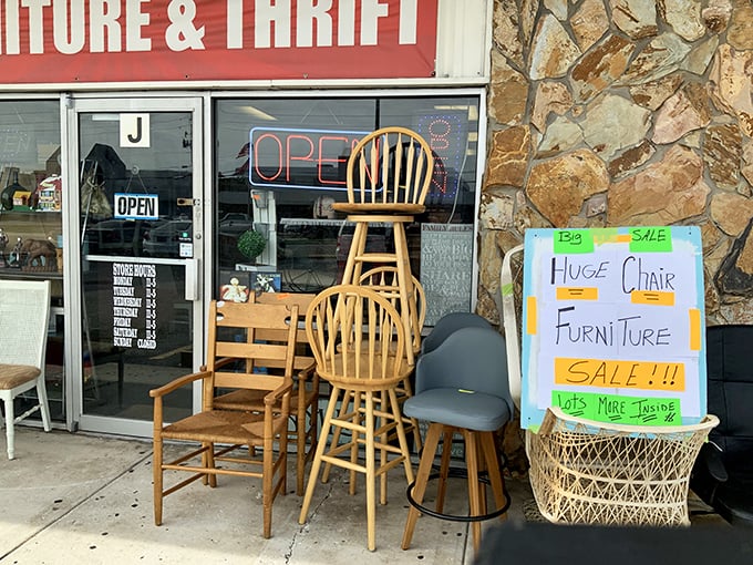 The sidewalk preview is like a furniture appetizer – those wooden chairs stacked with possibility and that handwritten sale sign promising more inside.