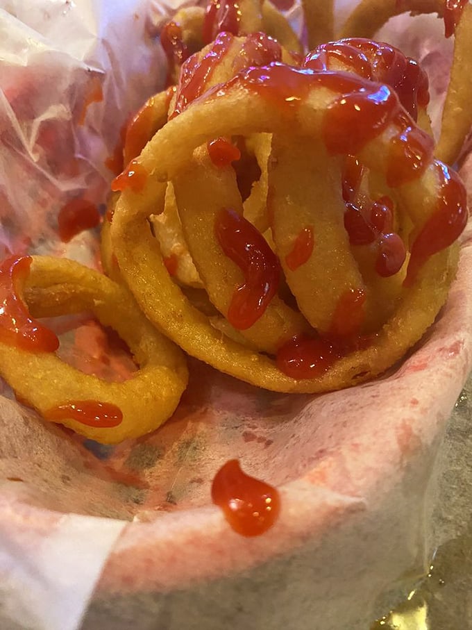 Onion rings wearing their Sunday best – perfectly battered, golden-fried, and drizzled with ketchup. Like edible jewelry for your basket.