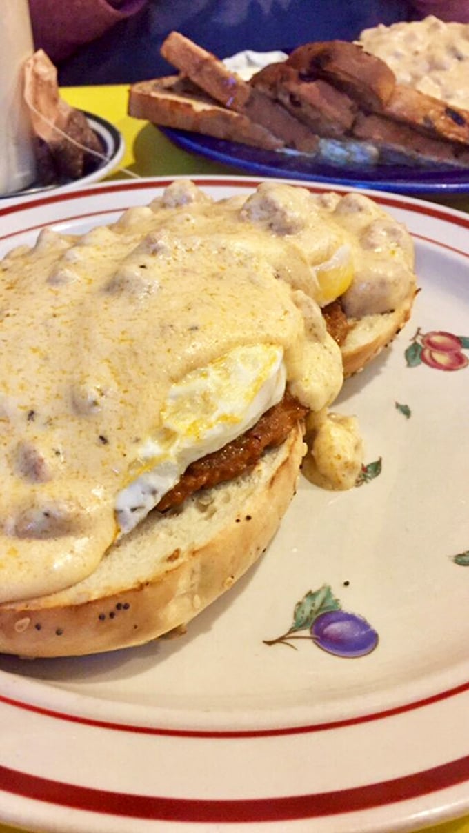 Breakfast engineering at its finest. Eggs, scallions, and gravy atop a golden waffle—it's like someone built a delicious breakfast skyscraper.