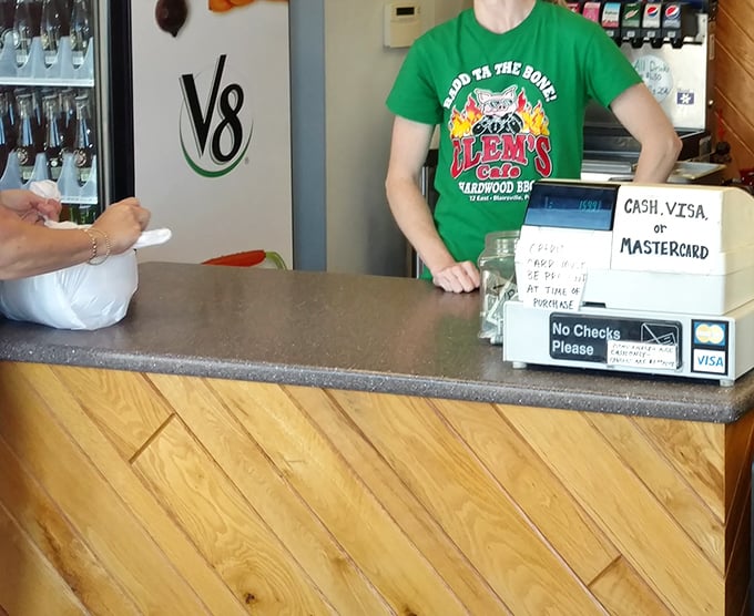 The ordering counter—where barbecue dreams begin their journey to reality. That "Good to the Bone" shirt speaks the absolute truth.