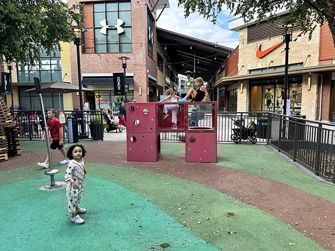 The children's play area—ingeniously positioned between Nike and Under Armour—keeps little ones entertained while parents score athletic wear deals.