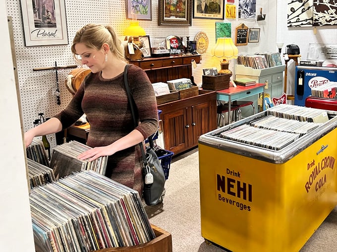 Vinyl revival headquarters where music lovers flip through history one album at a time. That yellow NEHI cooler is the perfect retro bonus.