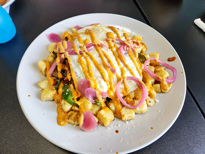A mountain of home fries topped with cheese sauce and pickled onions—because potatoes deserve to dress up fancy sometimes too.
