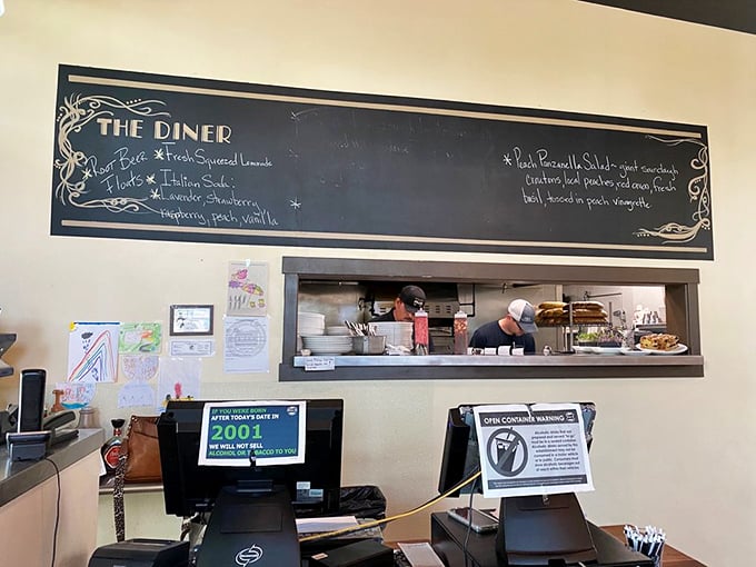 The heart of The Diner revealed: a chalkboard menu and open kitchen where breakfast dreams materialize. Theater and dining in one tidy package.