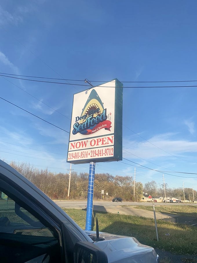 The roadside sign stands tall like a lighthouse guiding hungry travelers to this unexpected seafood haven. "NOW OPEN" might be the two most beautiful words in English.