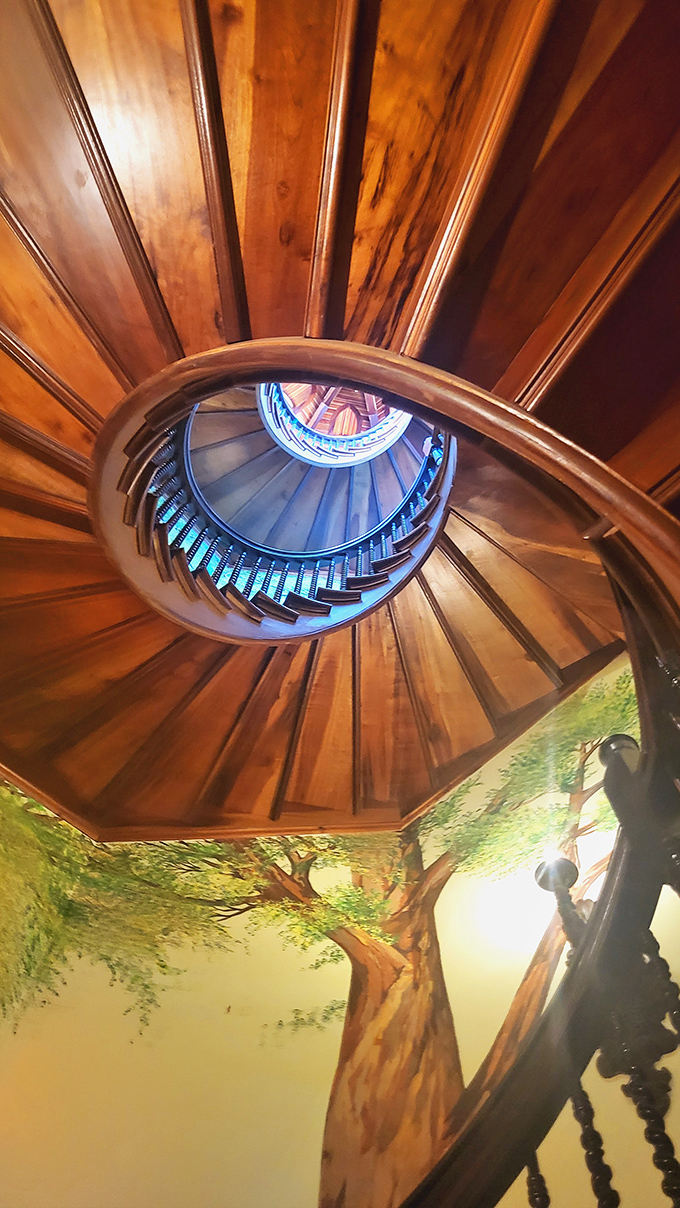 Looking up this spiral staircase reveals the castle's artistic soul—rich wood, stained glass, and murals combine in a dizzying display of craftsmanship.