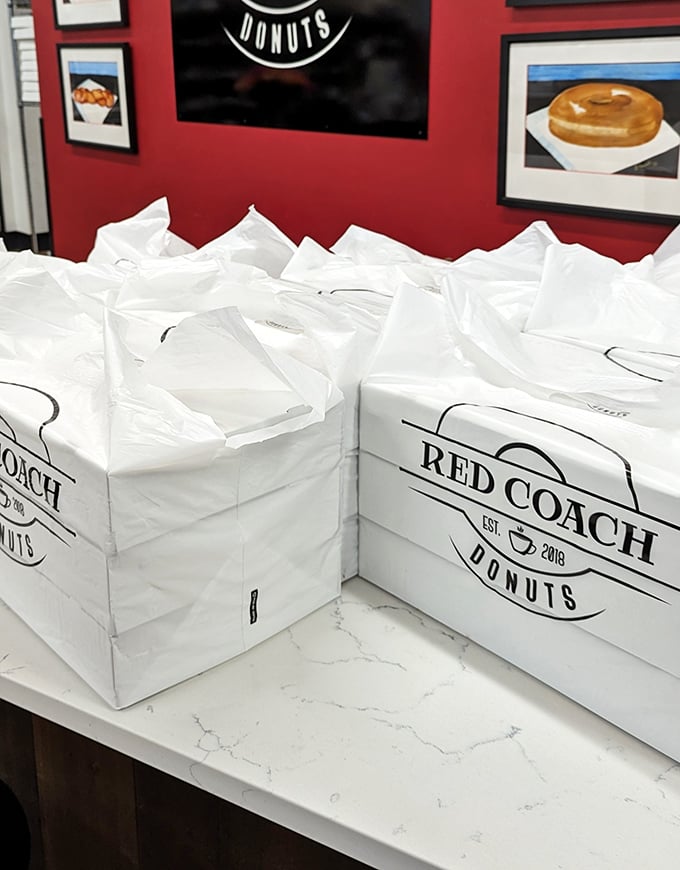 Those pristine white boxes hold promises of happiness—like little treasure chests where X marks the spot for "excellent donuts here."