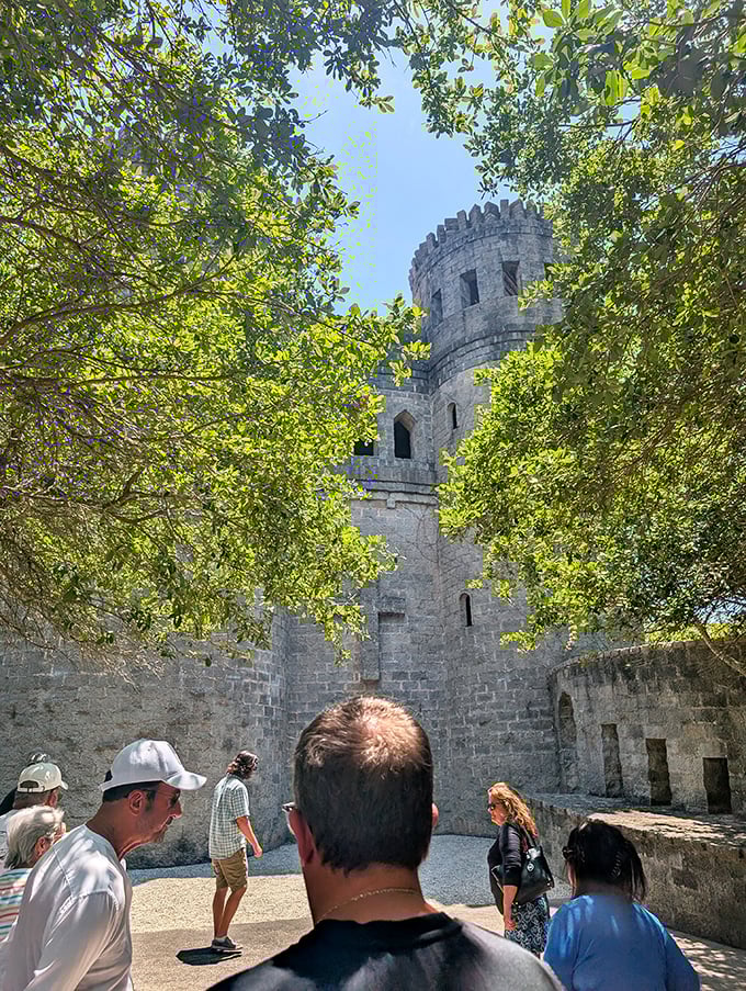 Visitors gather in the castle courtyard, their modern attire a charming anachronism against the medieval stonework backdrop.