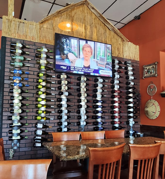 That impressive wall of wine bottles isn't just decoration—it's a liquid library of possibilities. The thatched roof above adds authentic charm to modern libations.
