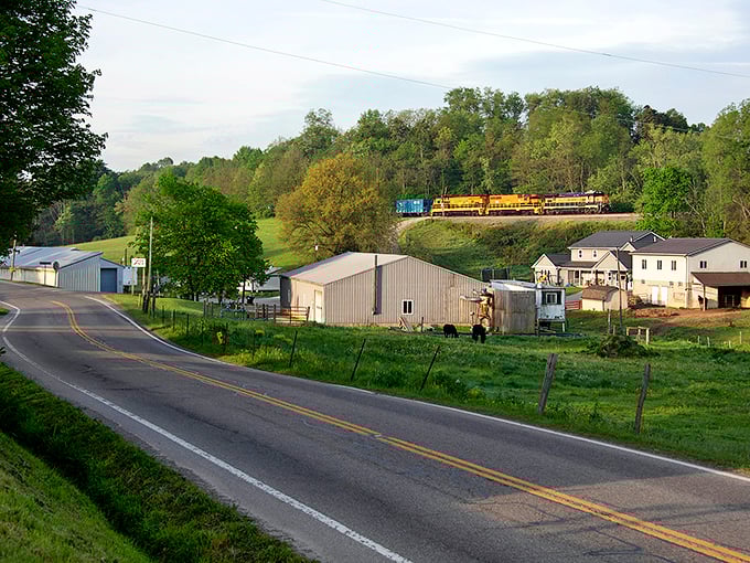 A quiet rural road with a train passing through - where the railroad and horse-drawn buggies still peacefully coexist.