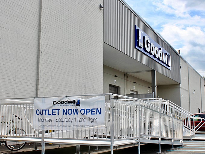 The "Outlet Now Open" banner welcomes adventurous thrifters to Goodwill's final frontier of bargain hunting. Gloves recommended, patience required!