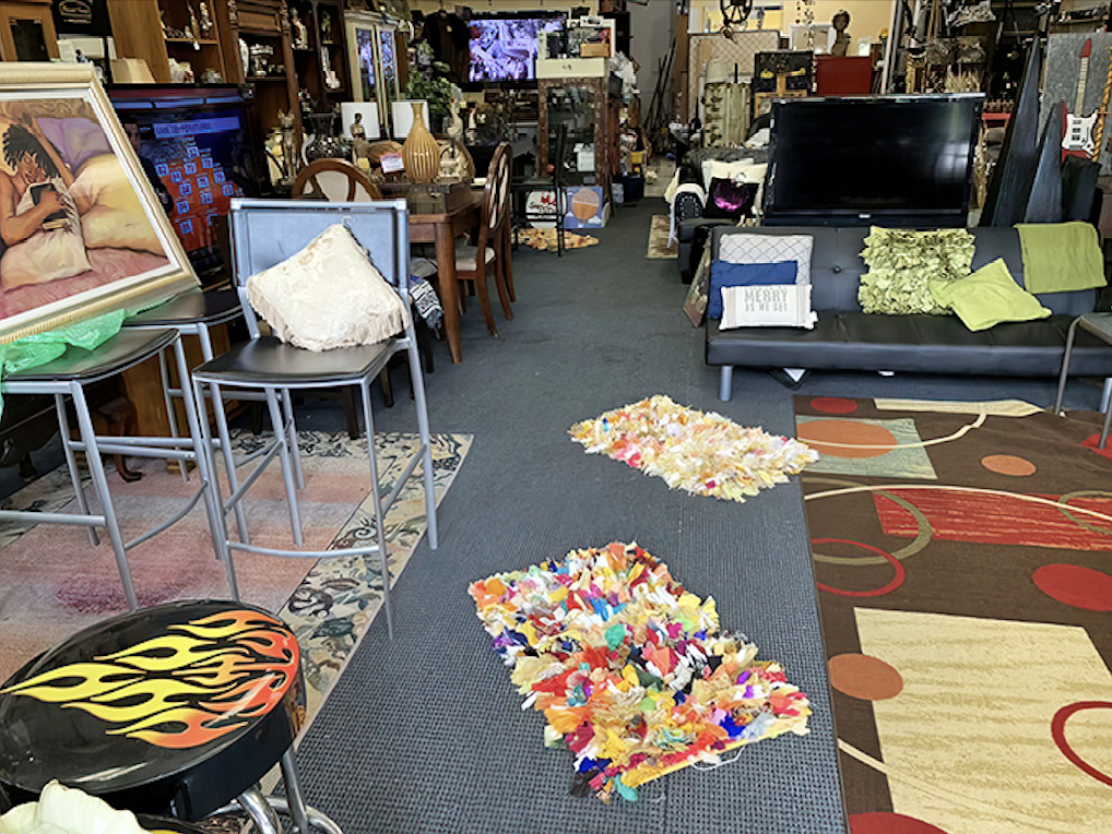 A treasure hunter's paradise where pathways wind through furniture islands, colorful rugs, and electronics—bring your compass and sense of adventure!