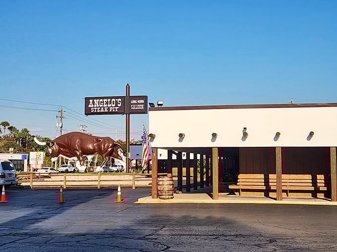 Big Gus, the iconic bull statue, stands guard outside Angelo's Steak Pit, welcoming hungry travelers with a silent promise of carnivorous delights within.