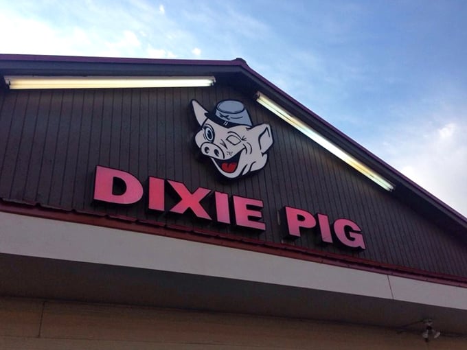 The winking cartoon pig on the sign isn't just cute—it's a promise of the smoky delights waiting inside this unassuming barbecue temple in Blytheville.