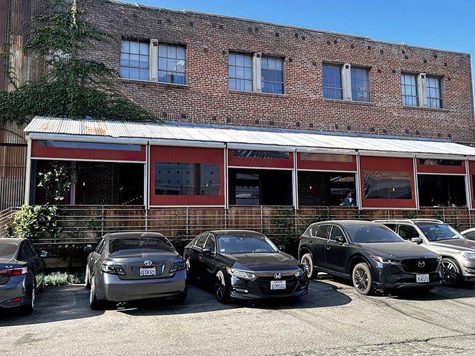 Bestia's unassuming brick exterior hides culinary treasures within, like finding a Michelin star in your neighborhood garage. The red awnings offer the only hint of the flavor explosion waiting inside.