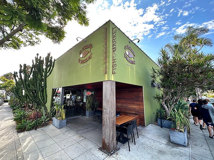 The distinctive green exterior of El Pescador stands like a seafood oasis amid La Jolla's upscale landscape, complete with California's signature cacti guardians.