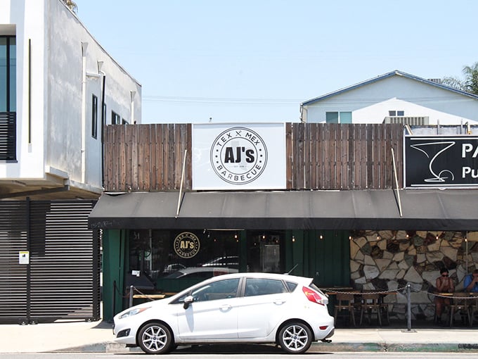 The unassuming storefront of AJ's might not scream "destination dining," but that stack of firewood hints at the smoky treasures waiting inside.