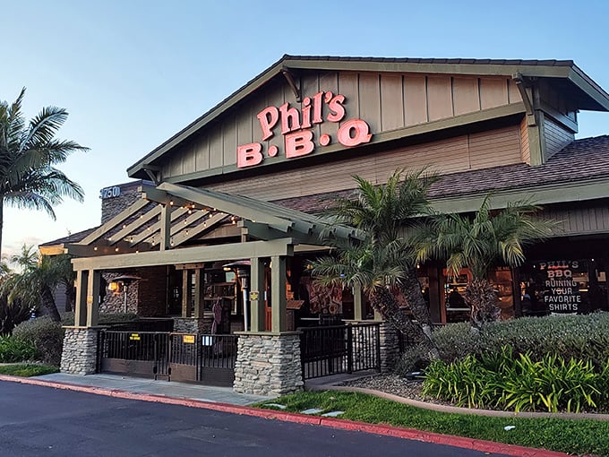 The California sunset casts a golden glow on Phil's BBQ, where palm trees and promise of smoky delights beckon hungry San Diegans nightly.