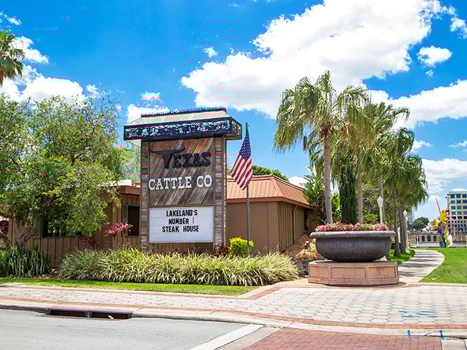 The unassuming exterior of Texas Cattle Company stands like a carnivore's oasis amid Lakeland's palm trees, promising meaty delights behind its rustic wooden façade.
