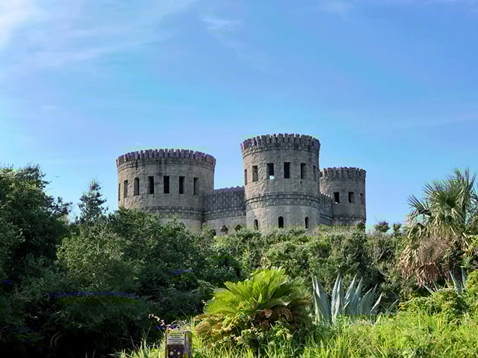 Medieval dreams rise from Florida's coastal landscape—Castle Otttis stands defiantly against the blue sky, its stone towers emerging from lush subtropical vegetation.