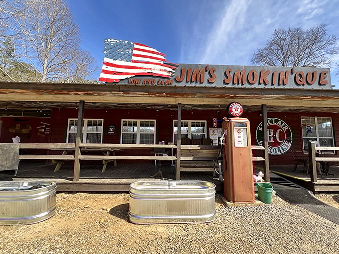 The American flag waves proudly above Jim's Smokin' Que, where that vintage gas pump isn't just decoration—it's a promise of old-school authenticity.