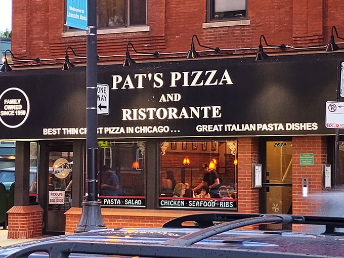 Pat’s Pizza & Ristorante’s classic brick exterior and glowing sign make it a welcoming landmark for pizza lovers along Lincoln Avenue after dark.