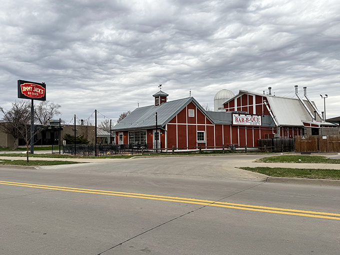 The iconic red barn exterior of Jimmy Jack's stands like a barbecue beacon, promising smoky delights within its rustic walls.