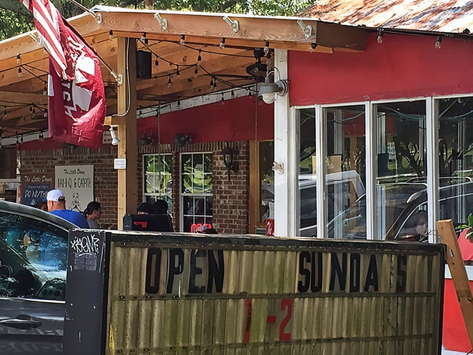 The weathered "OPEN SUNDAY" sign and rustic porch tell you everything – authentic BBQ doesn't need fancy advertising, just smoke signals.