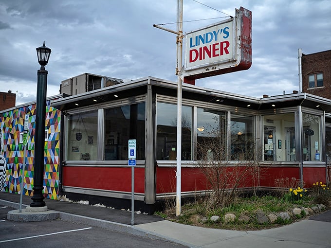The iconic blue and red sign of Lindy's Diner stands sentinel against moody New Hampshire skies, promising comfort food salvation to weary travelers.