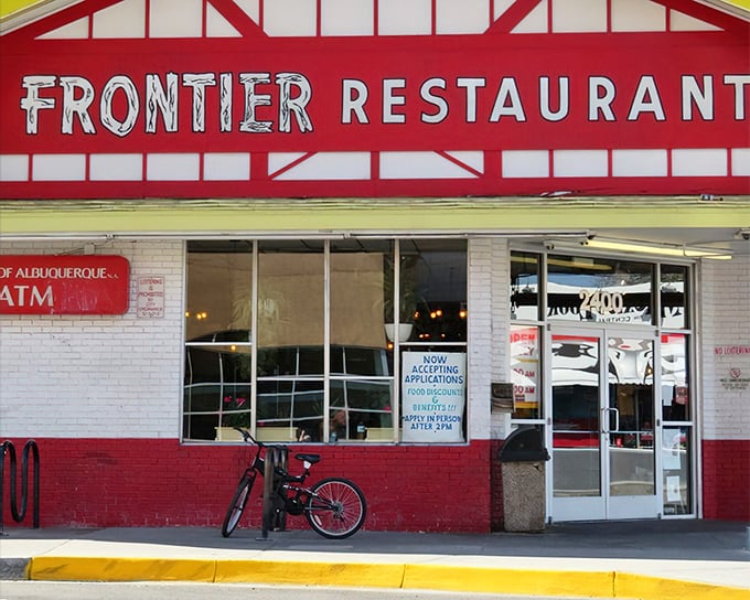 The iconic red and white facade of Frontier Restaurant stands like a beacon for hungry souls across from UNM, promising salvation in the form of green chile.
