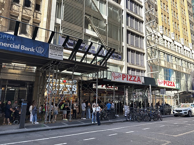 The pilgrimage begins! Joe's Pizza on Broadway draws crowds under its iconic red awning—a beacon of hope for the pizza-obsessed in Midtown Manhattan.