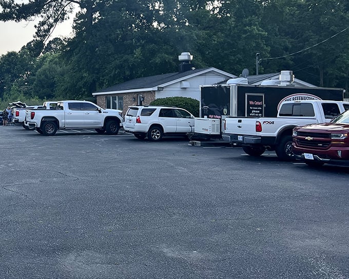 The parking lot tells the real story—trucks lined up like faithful pilgrims making their carnivorous journey to the promised land of ribeye.