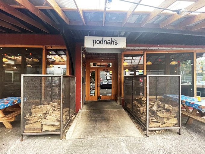 The entrance to barbecue paradise. Those wood stacks flanking the door aren't decorative – they're the secret behind that intoxicating smoky aroma that greets you.