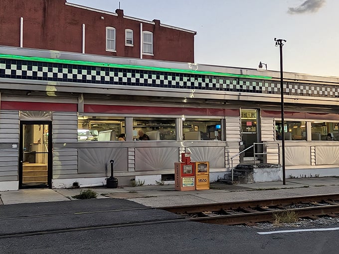 The classic checkerboard trim and stainless steel facade of Lincoln Diner gleams in the evening light, a beacon for hungry travelers and history buffs alike.